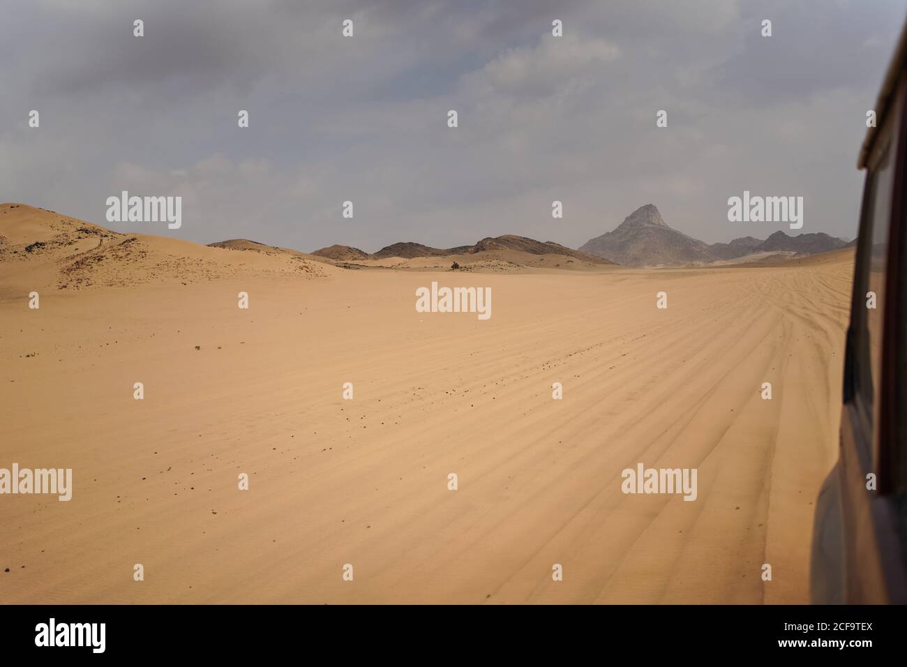 Scenic landscape of sun rays through clouds in desert from car window ...