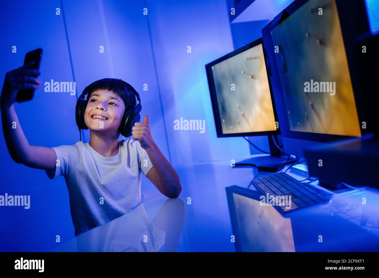 Content male child in headphones taking selfie on cellphone while ...