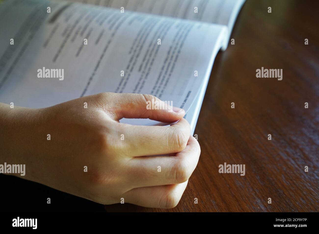 Close up hand holding textbook Stock Photo - Alamy
