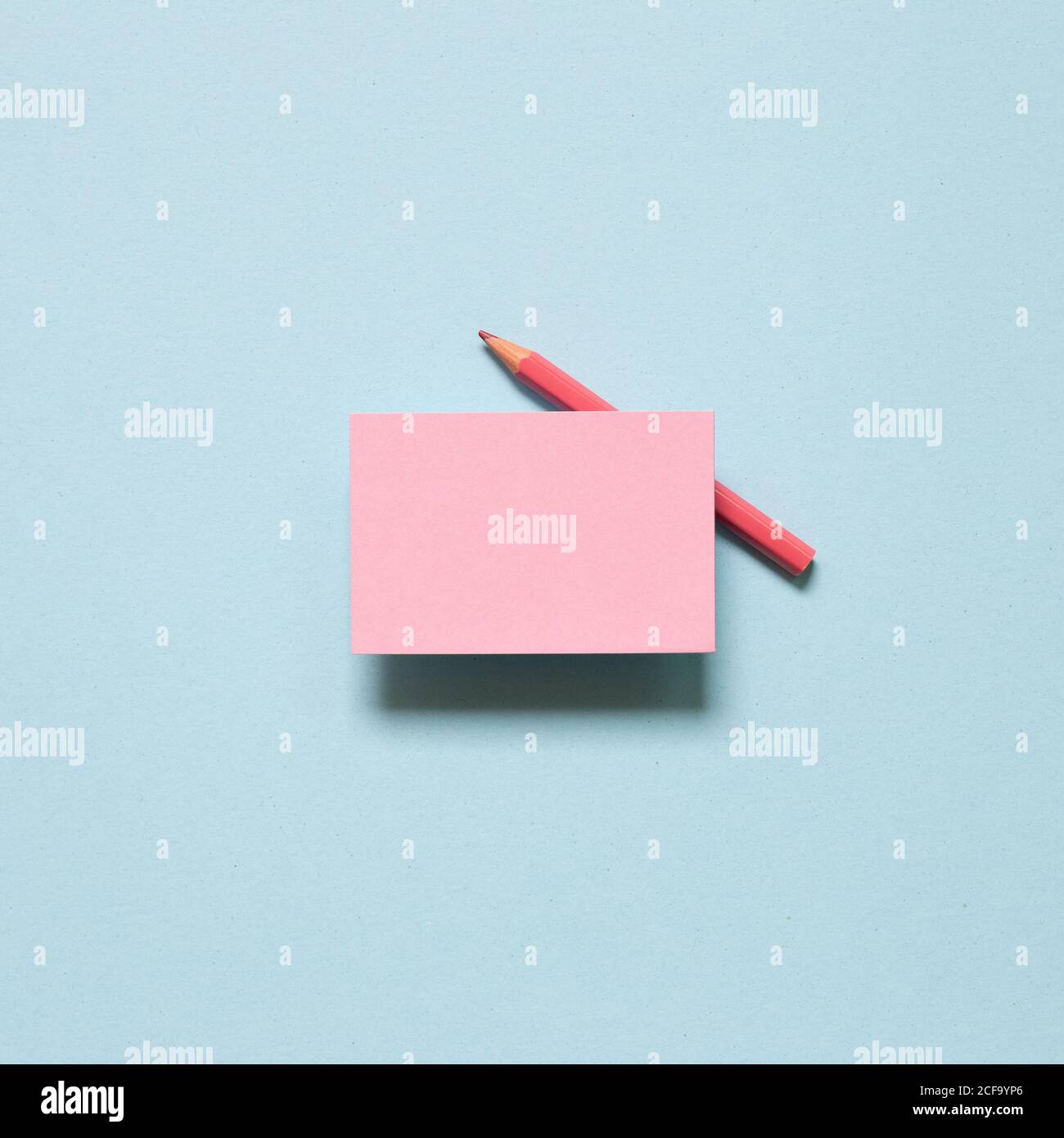 Pink memo paper, sticky notes with colored pencil on blue background ...