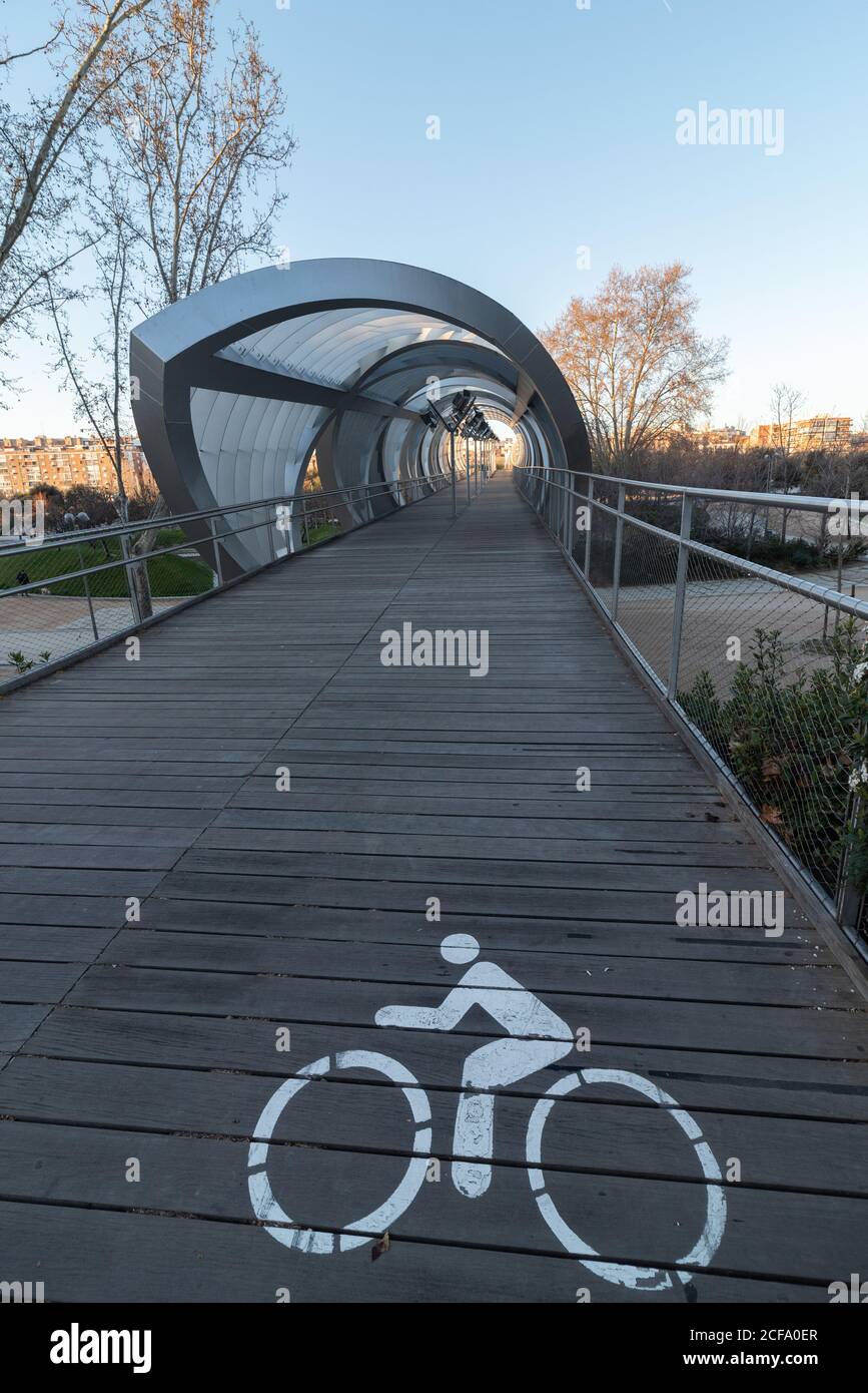 Perspective view of paved wooden bike path going to futuristic gallery ...