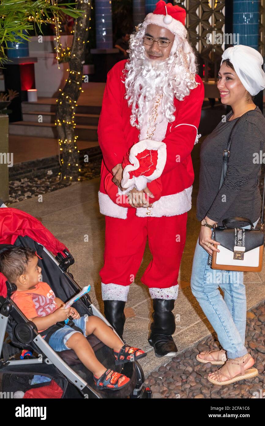 Thai Father Christmas with mother and child, Patong Beach, Phuket ...