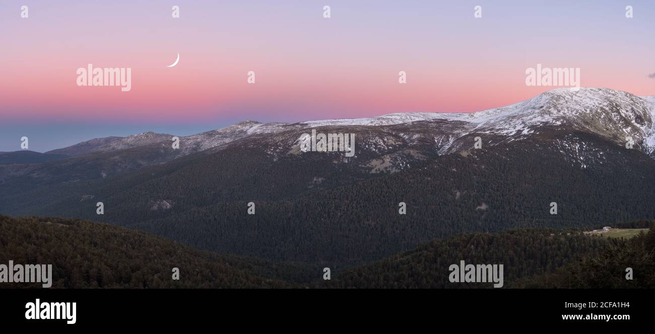 Breathtaking wide angle view of snowy mountain range against evening ...