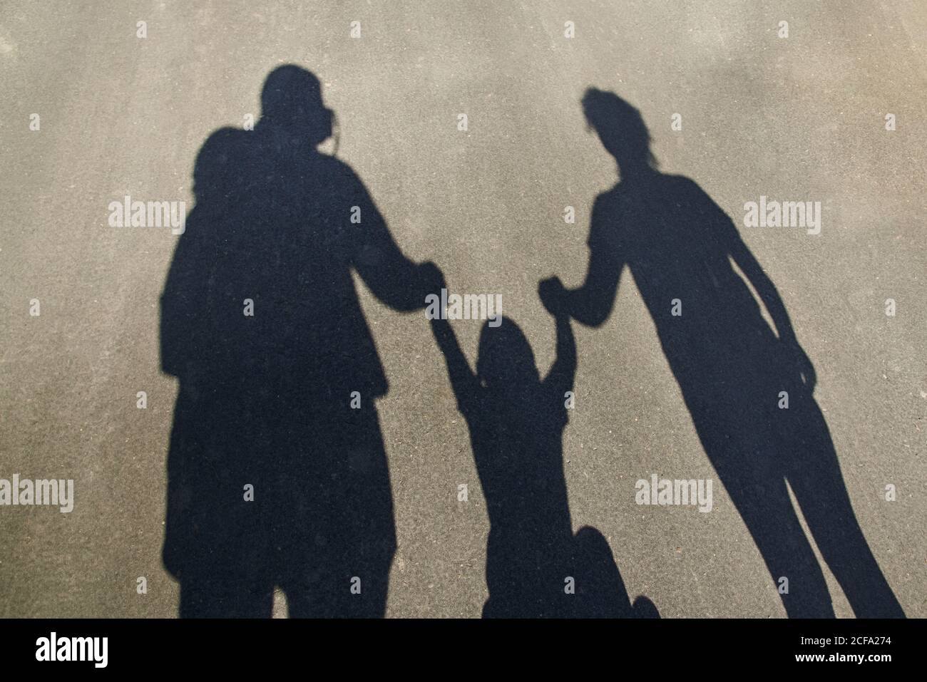 Silhouette, shadow of a family on the pavement: dad, mom and baby ...