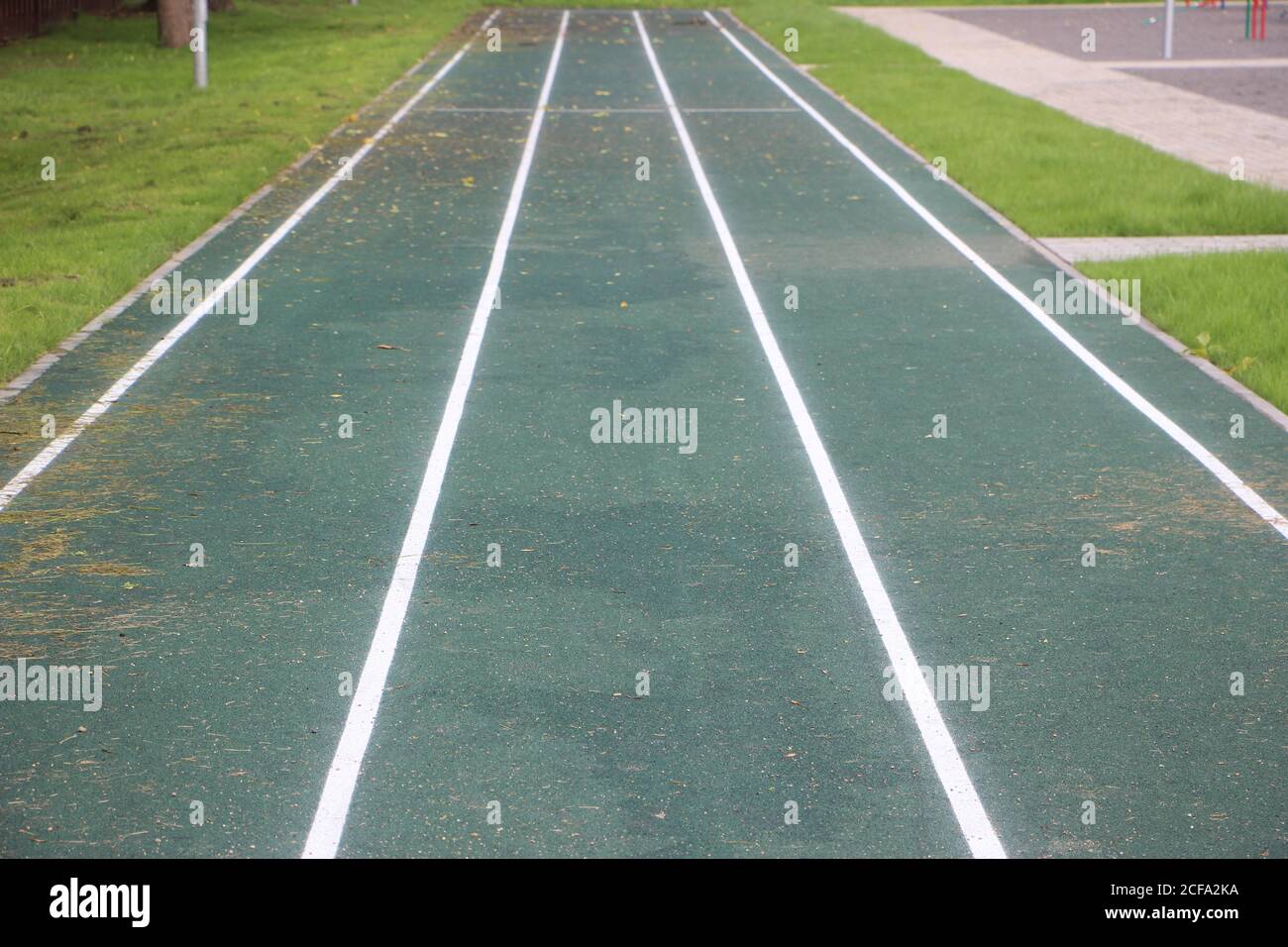 Running track with green grass around. Speed concept Stock Photo - Alamy
