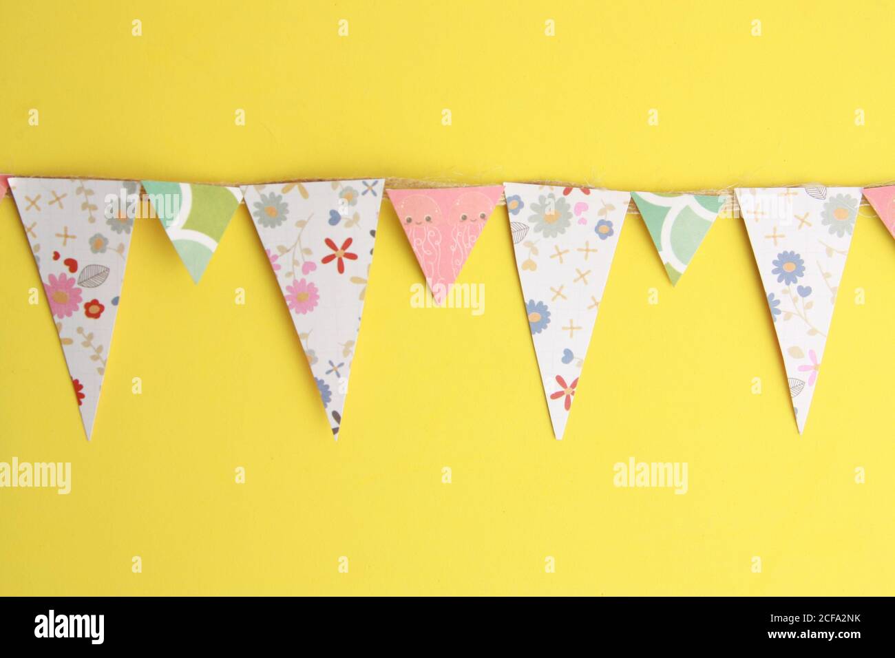 Colourful paper party flags on the yellow background Stock Photo - Alamy