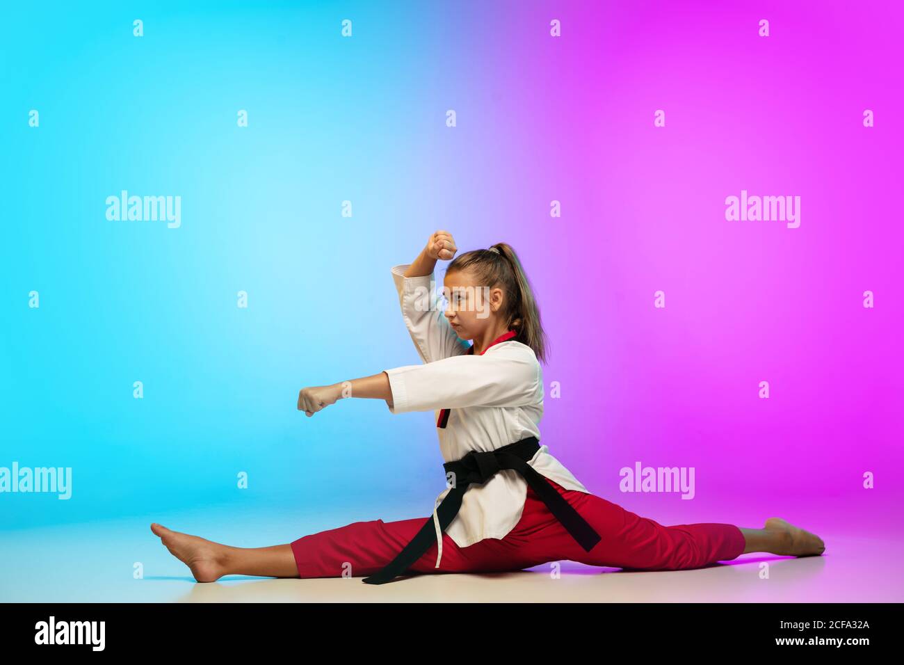 Strong. Karate, taekwondo girl with black belt isolated on gradient ...