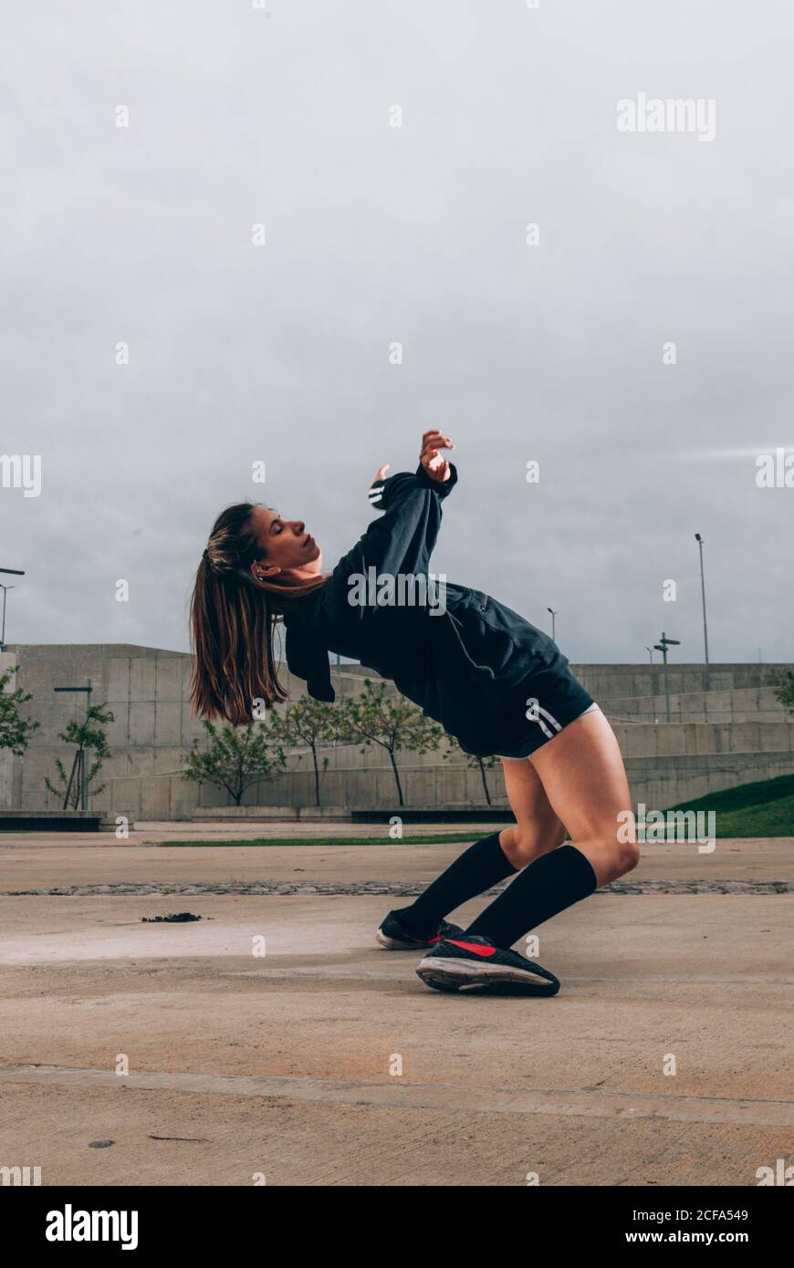 Female hip hop dancer in active wear striking pose outdoors Stock Photo ...