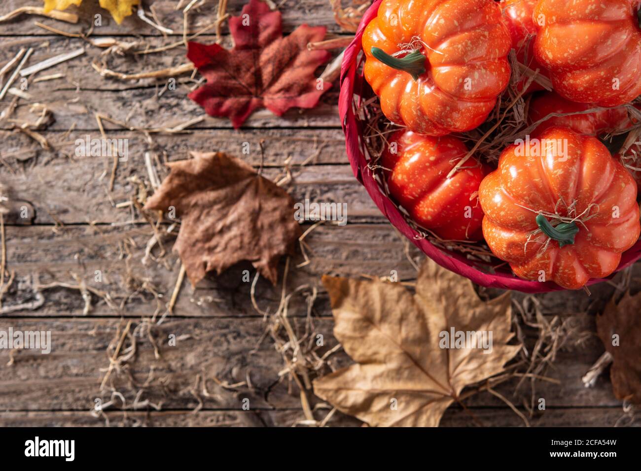 Pumpkins in a red basket on rustic wooden table Stock Photo - Alamy