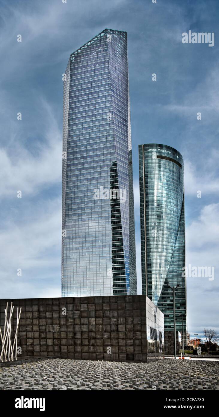 High rise glass towers of modern buildings against blue cloudy sky ...
