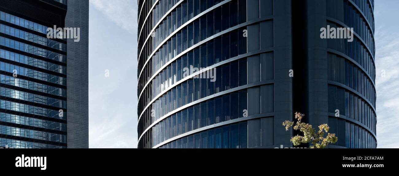 High rise glass towers of modern buildings against blue cloudy sky ...
