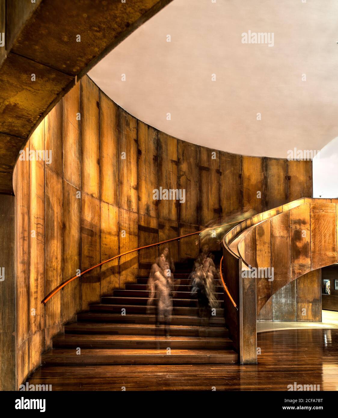 Staircase with rusty metal panels on walls and copper railing in ...