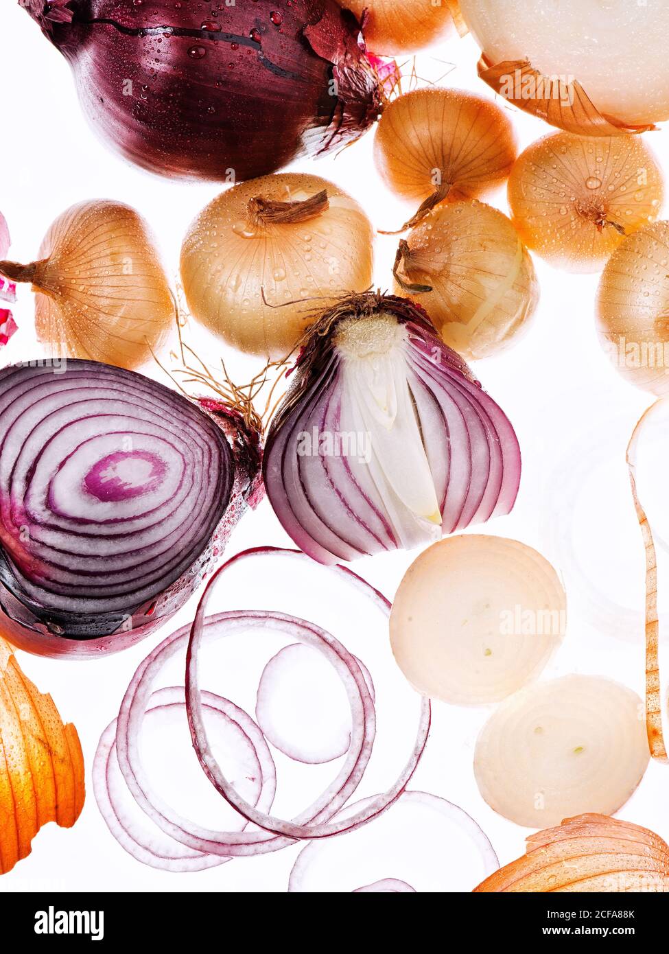 Bunch of fresh whole and sliced red and white onions of various shapes ...