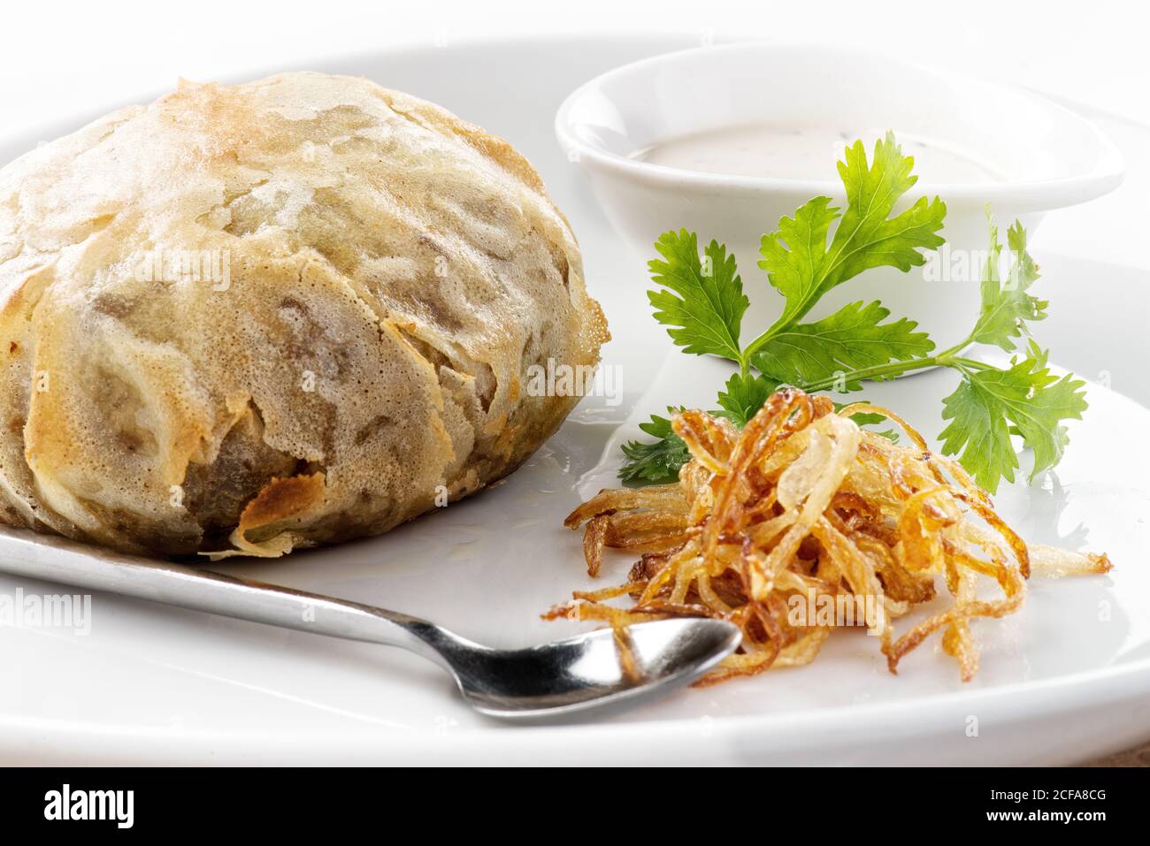 Closeup of traditional Lebanese dish with puff pastry and fish served ...