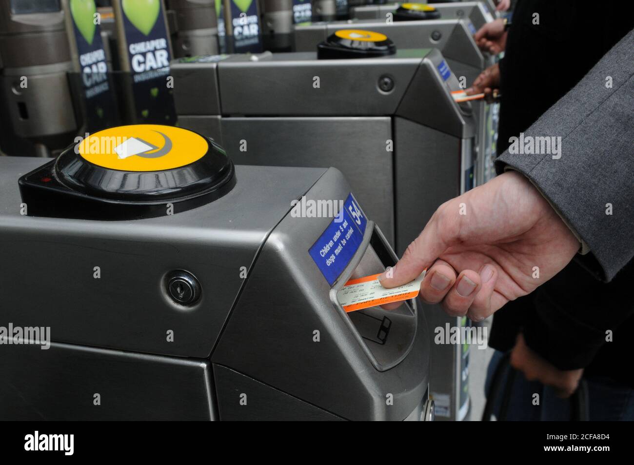 Hand putting train ticket into a TFL stations ticket barrier in Greater ...