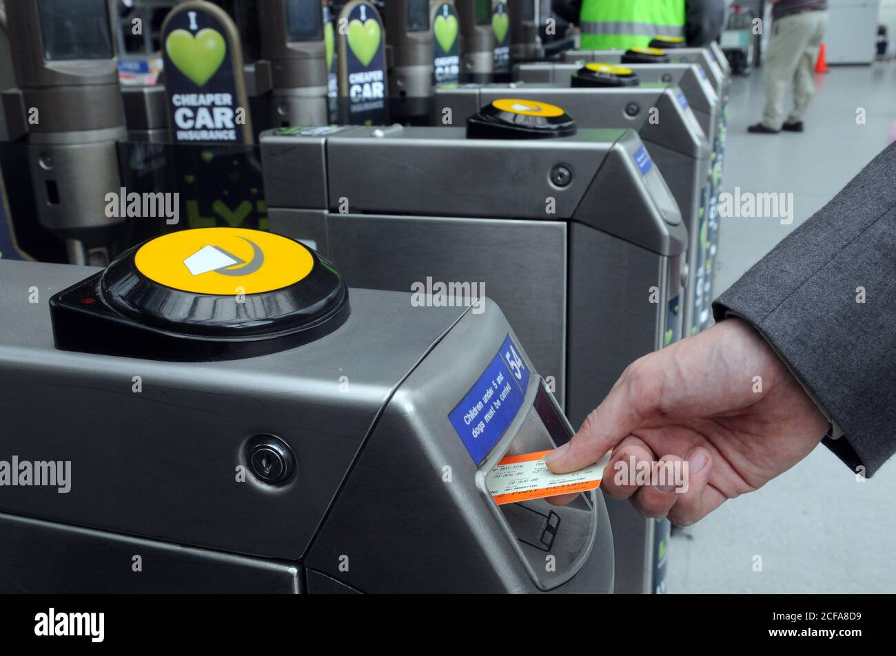 Hand putting train ticket into a TFL stations ticket barrier in Greater ...