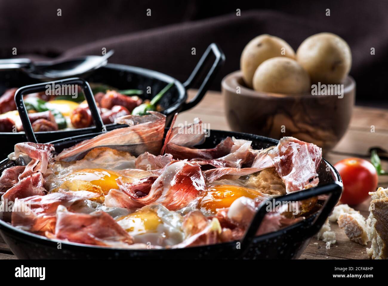 Pan with fried eggs with traditional Spanish iberian ham served on ...