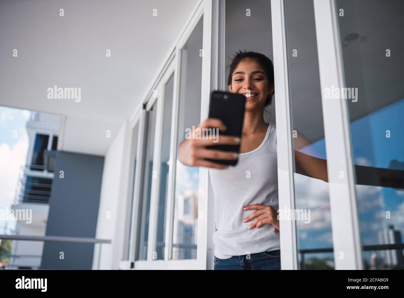 Beautiful brunette Hispanic Woman taking selfie on mobile phone and ...