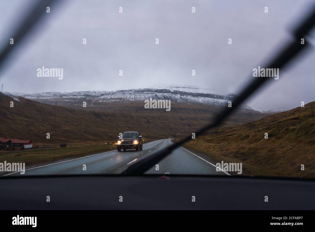 from inside a car view of a road in a raining day with a snowy mountain ...