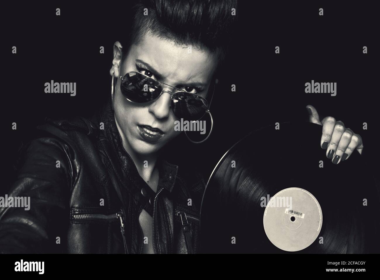 Angry confident female rocker in leather jacket and aviator sunglasses ...