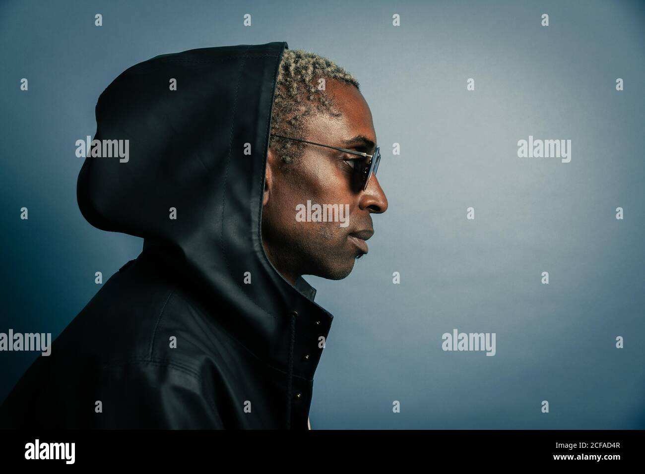 Side view of adult African American male in hooded coat and trendy ...