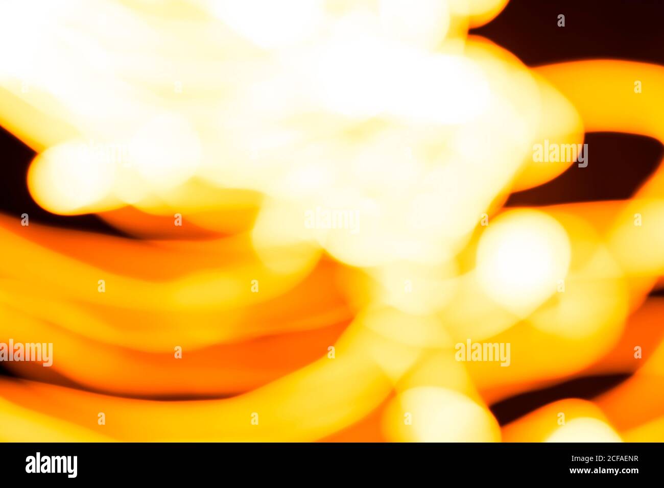 Blurred moving fire lights background, yellow, orange and white colors ...