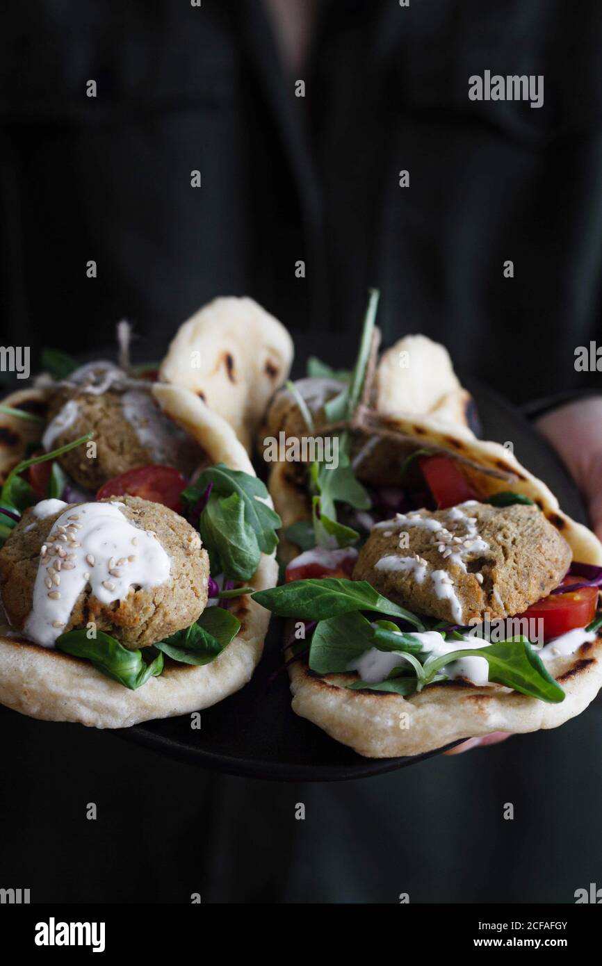 Falafel and fresh vegetables in pita bread on plate for eating ...