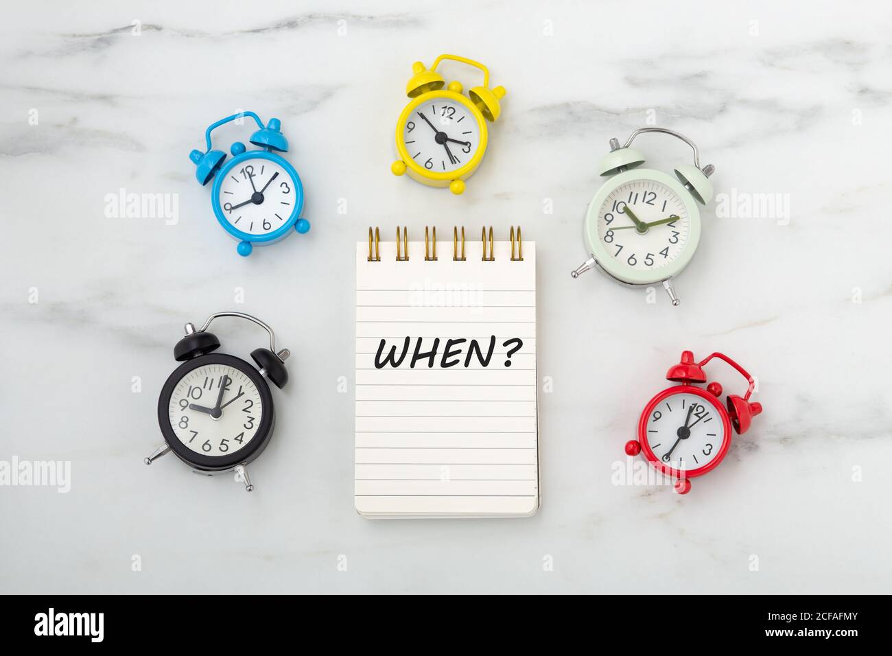 Clocks with various time and when question on notebook, top view Stock ...