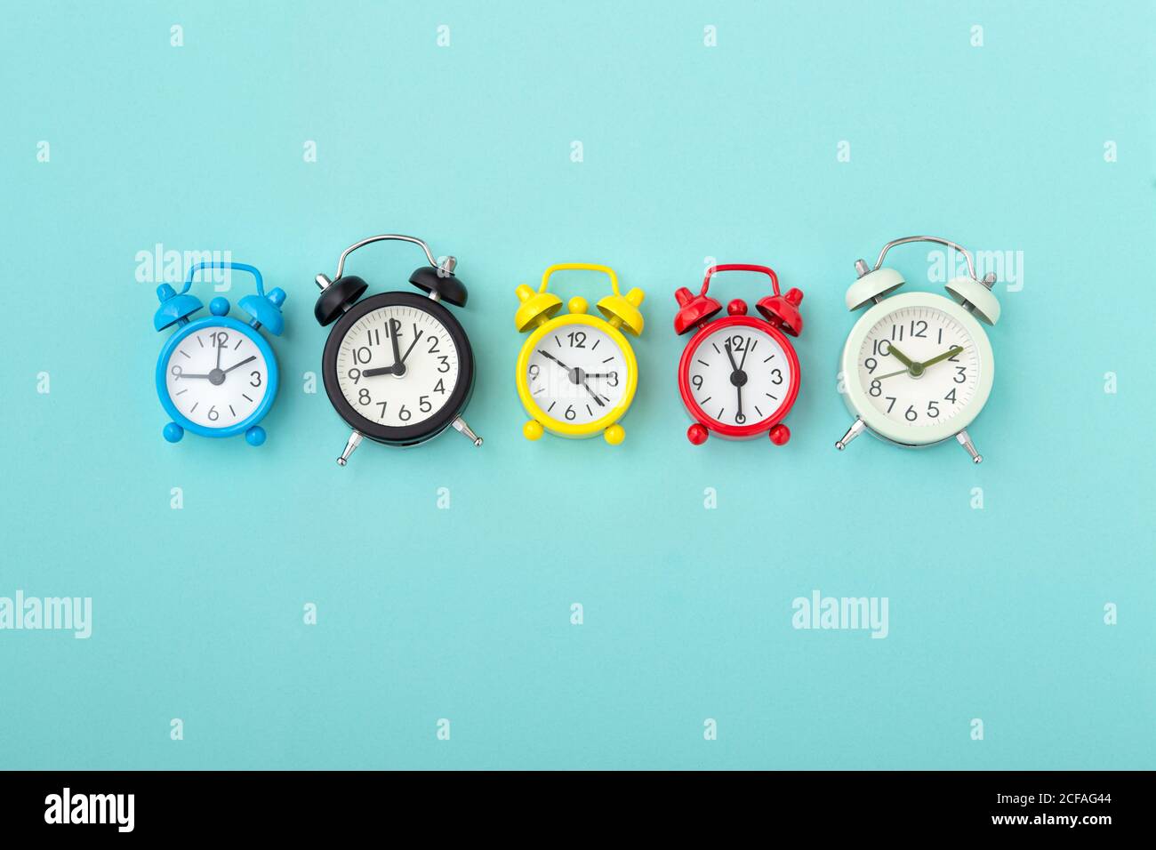 Clocks with various time and color on blue background, flat lay Stock ...