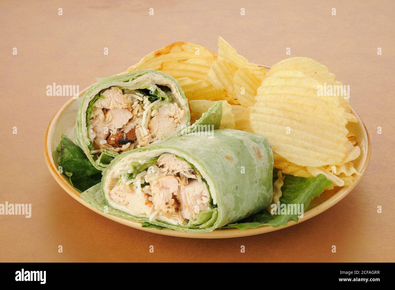 A plate of chicken caesar wraps with potato chips Stock Photo - Alamy