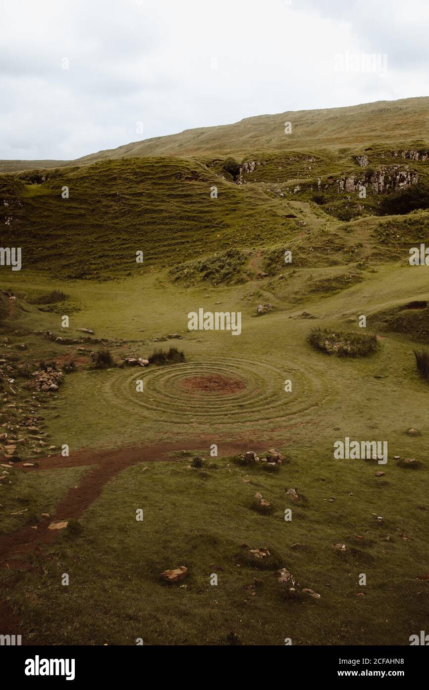 Mountain valley covered with green grass and mysterious spiral ...