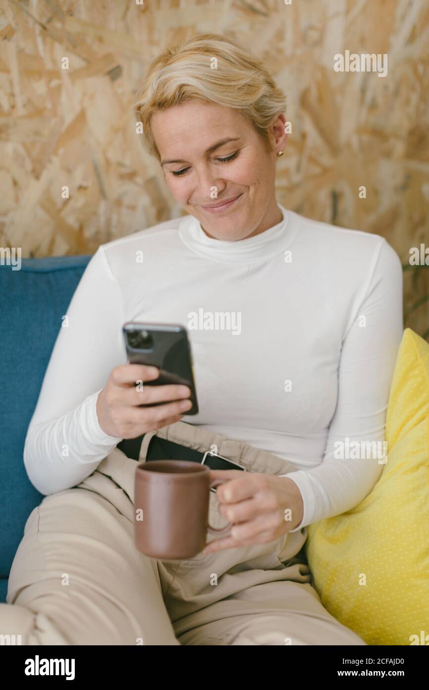 Blonde businessWoman with short hair chilling on cozy sofa in office ...