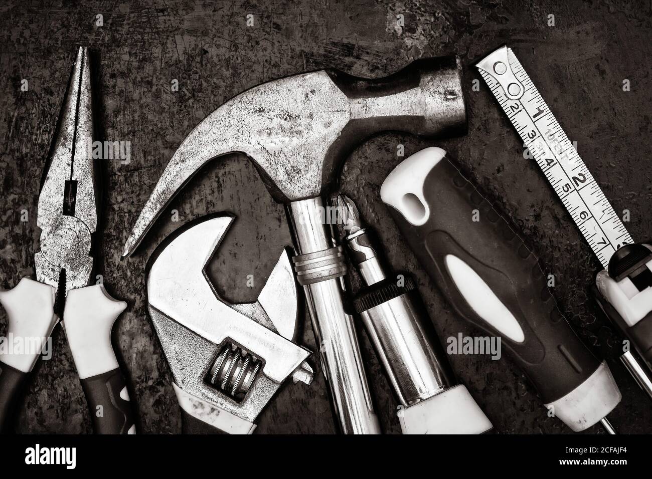 Black and white image of a set of tools on a textured metallic ...