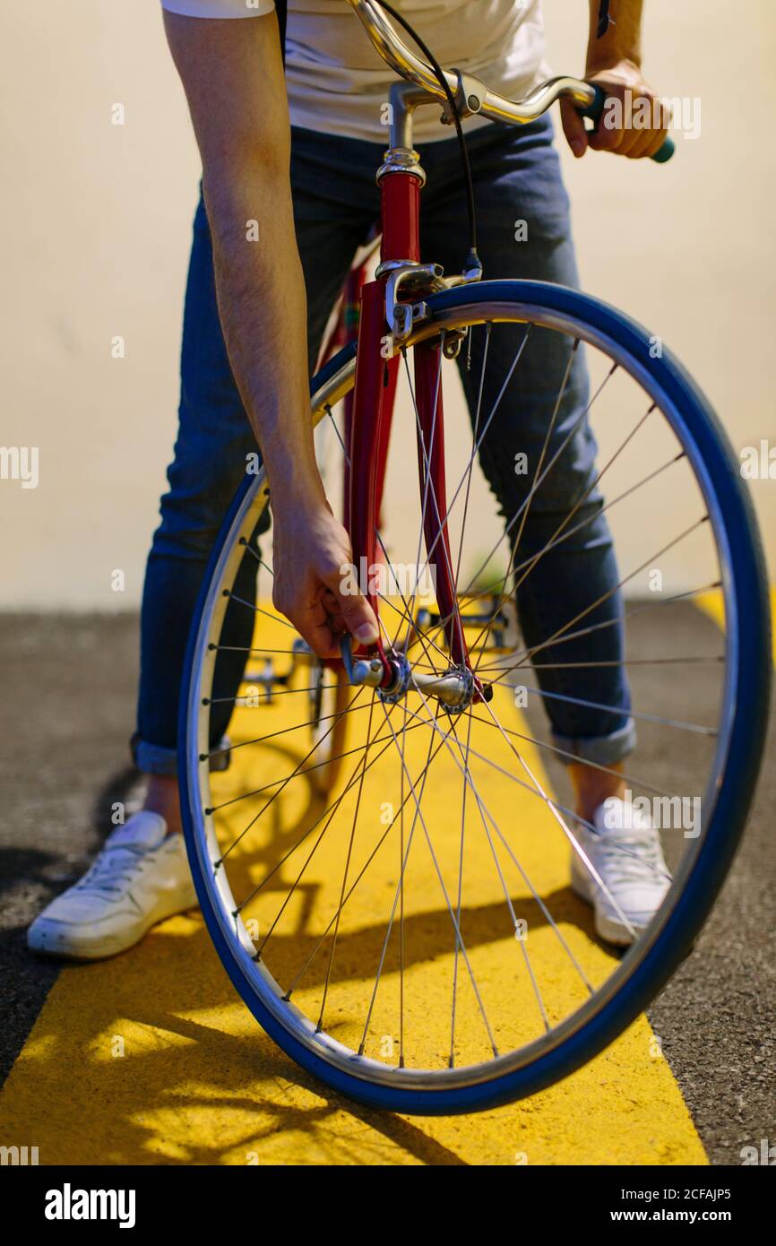 Close-up front view of unrecognizable man setting up a bike at night ...