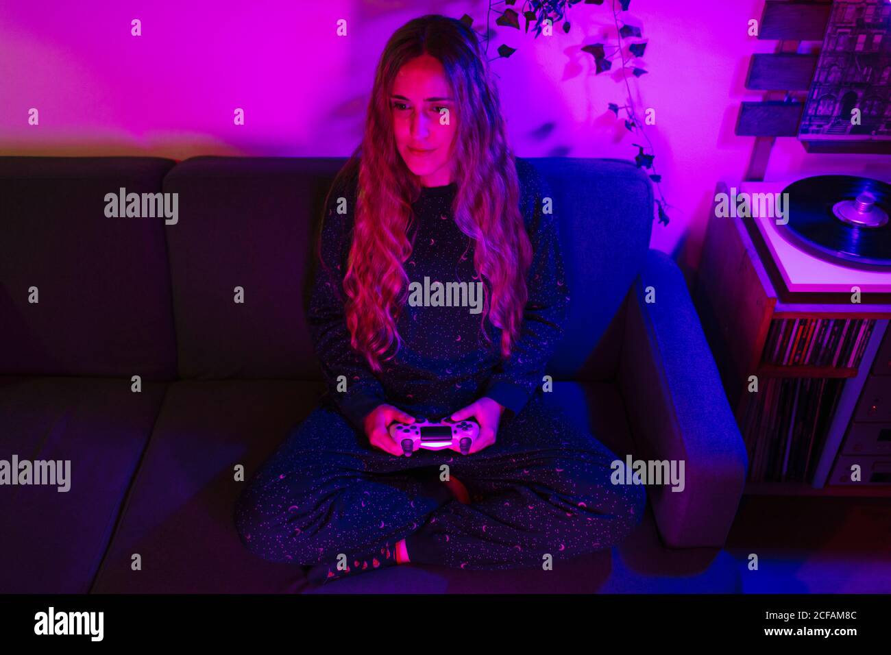 Happy girl playing video games in pajama at night in Corona Times. High ...