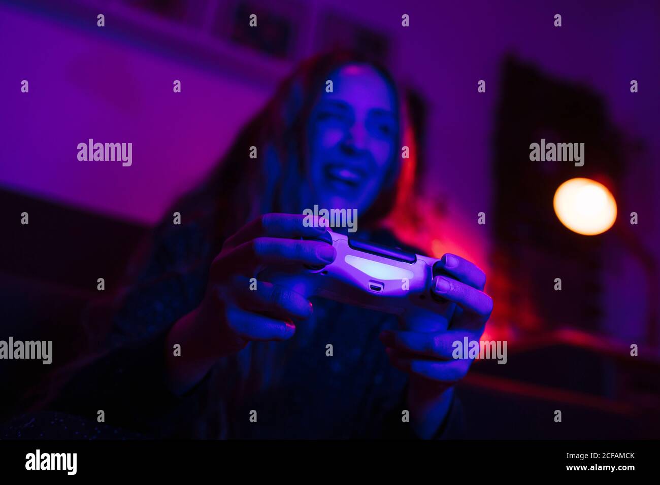Close-up view of a smiley girl's hands holding a controller and playing ...