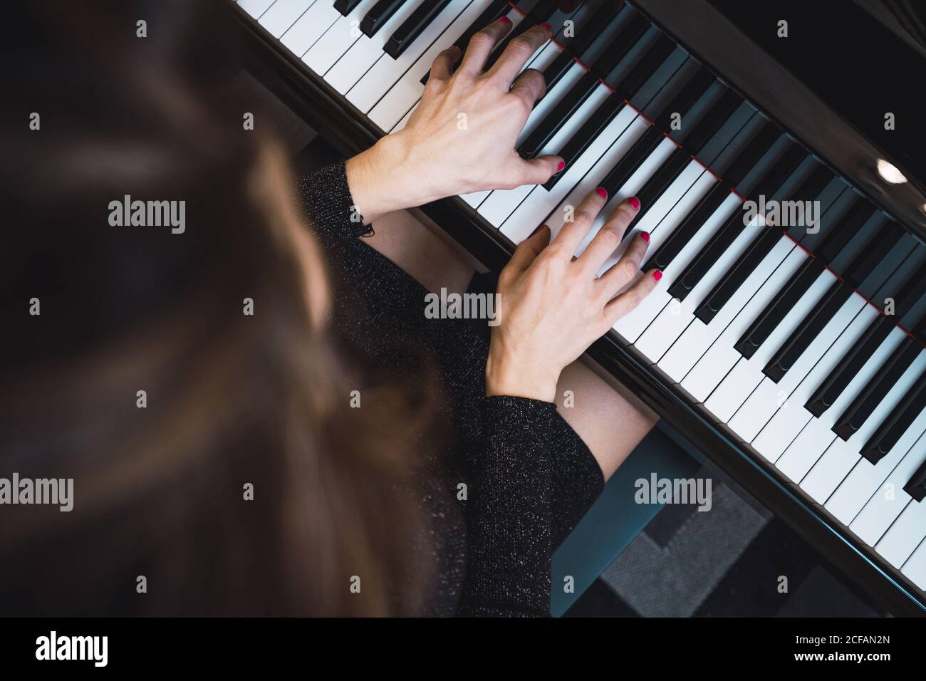 Top view of anonymous Woman musician playing on piano in room Stock ...