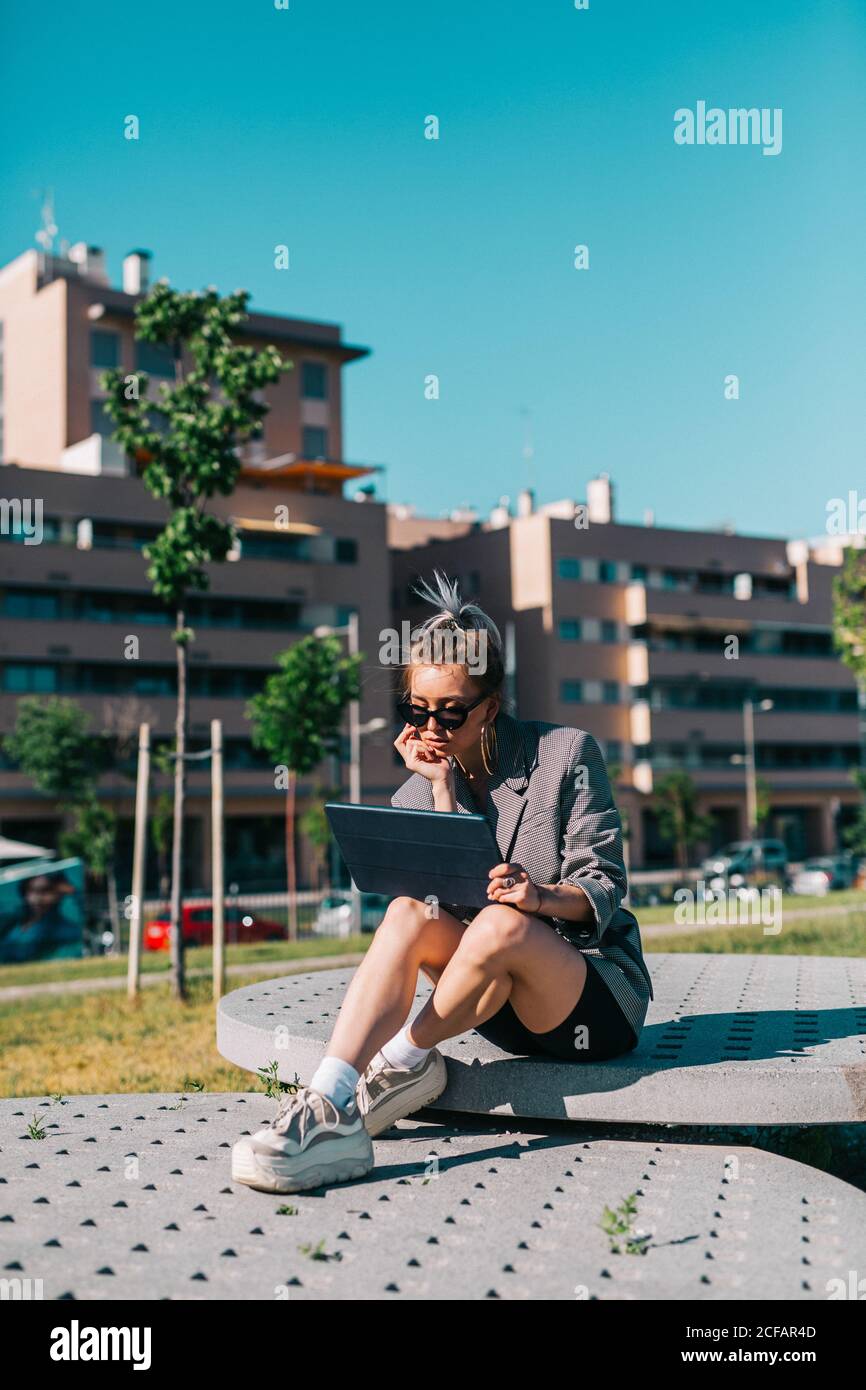 trendy businessWoman working outside sitting on round decorative panel ...