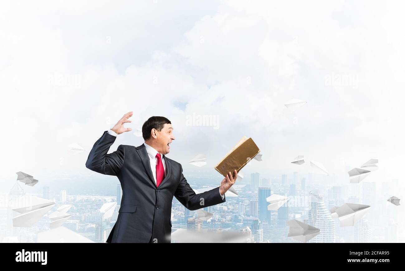 Expressive businessman looking in open book Stock Photo - Alamy
