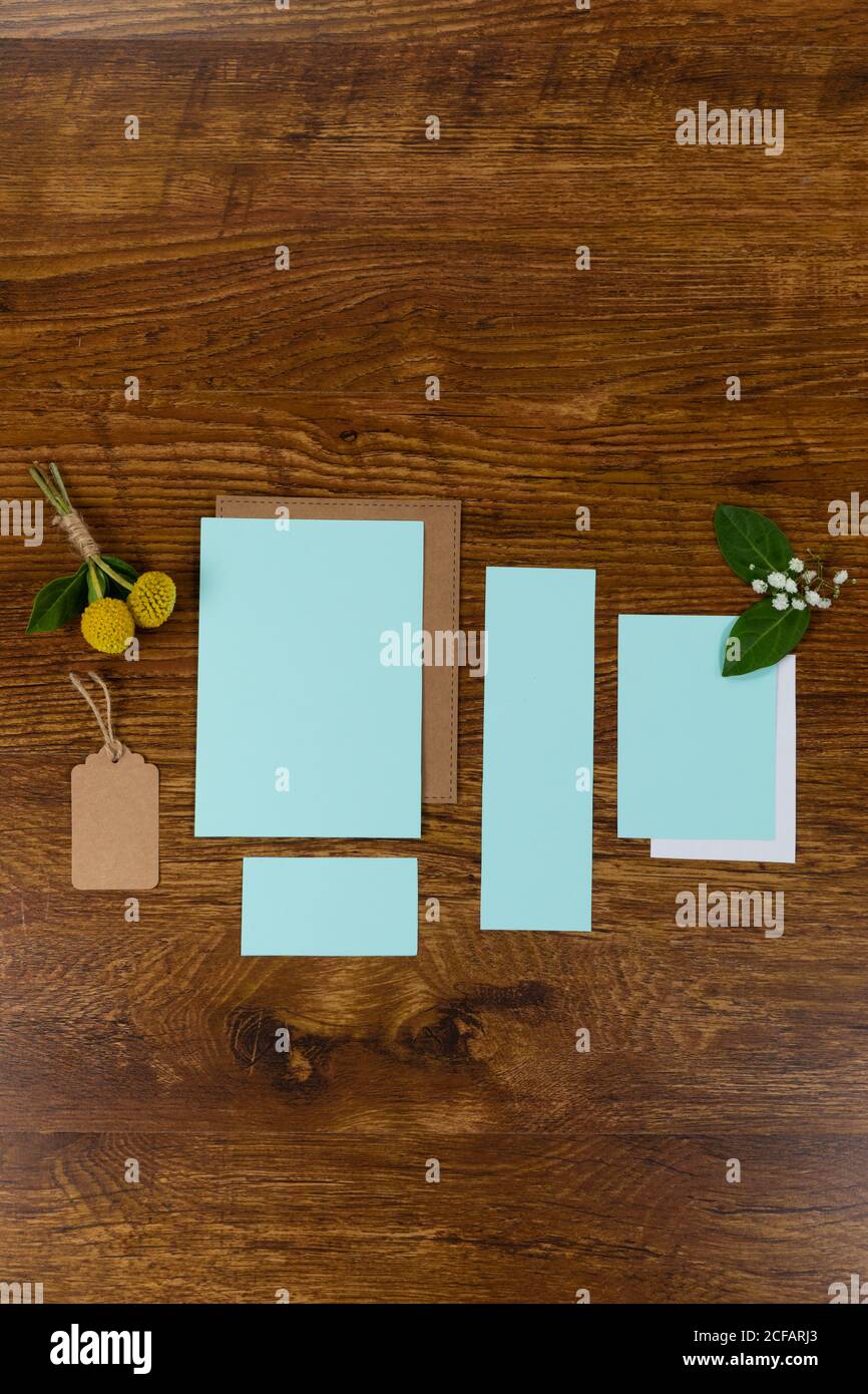 Notebook and blue sheet of papers surrounding by flowers on a wood ...