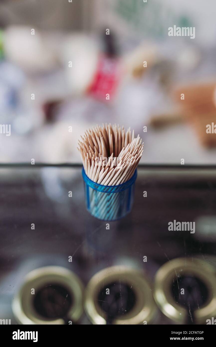 From above wooden stick toothpicks in a small blue container on blurred ...