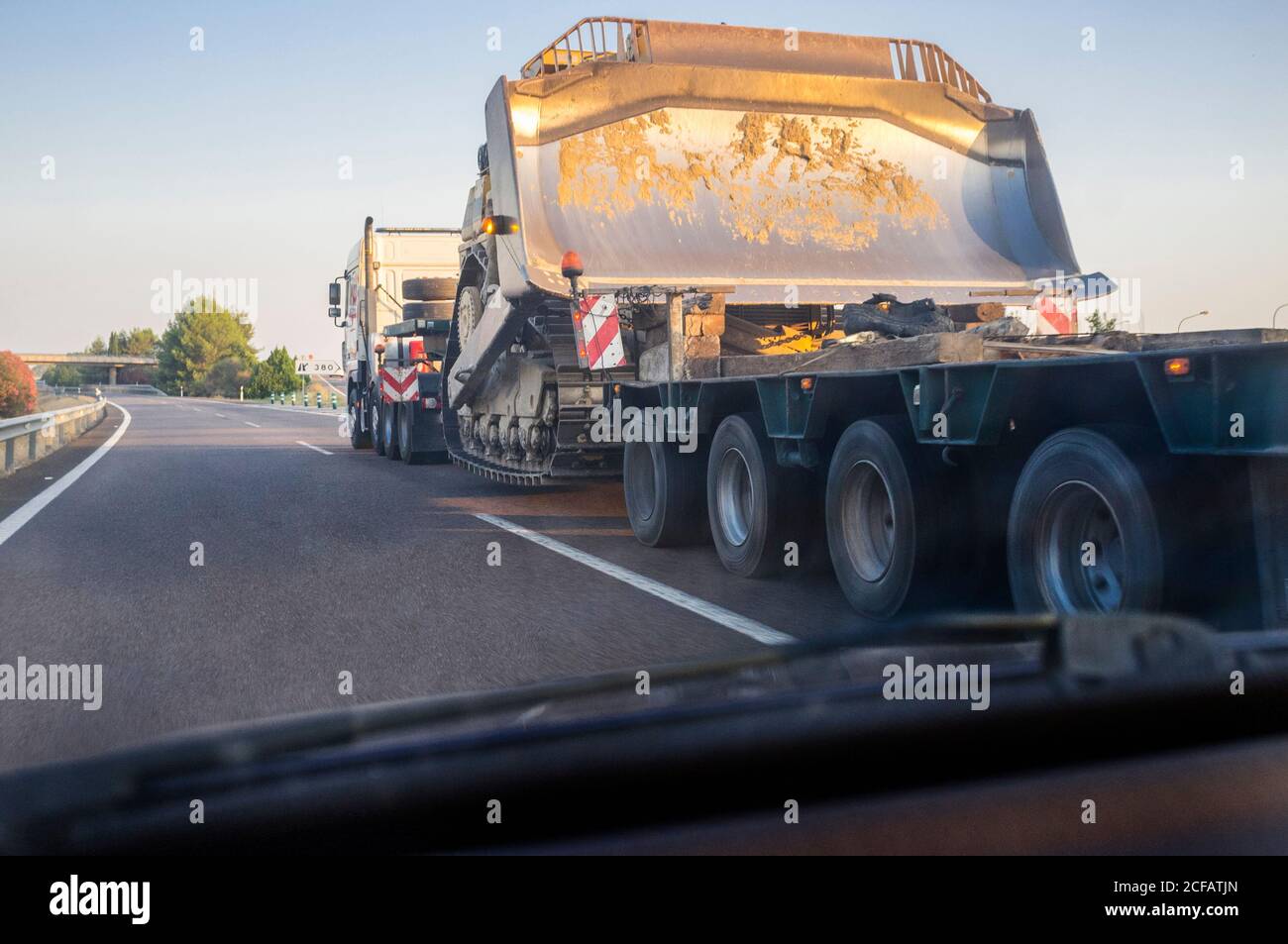 Oversize load truck transporting a huge excavator machine. View from ...