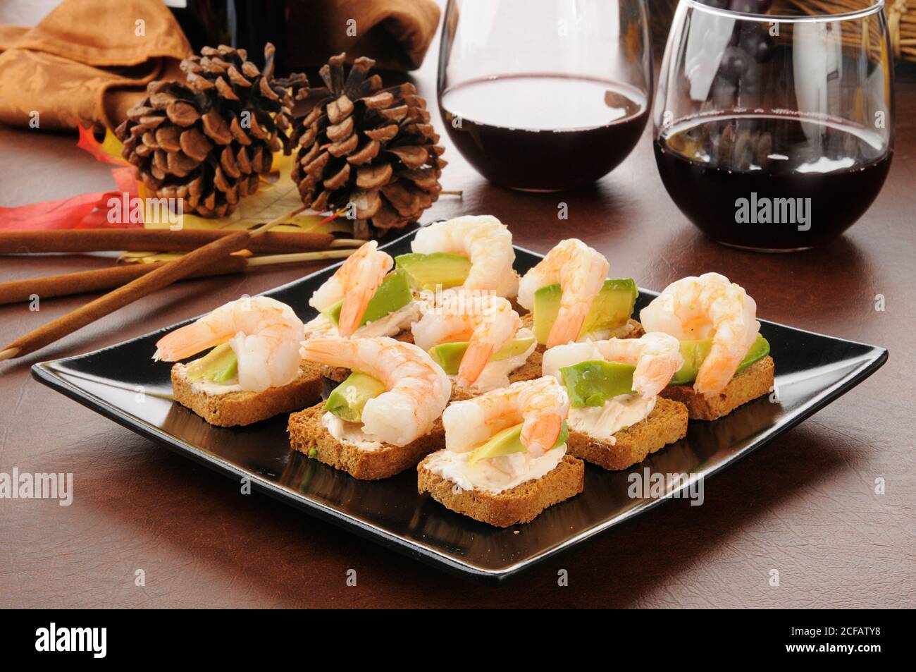 Shrimp avocado canapes on mini toasts with red wine Stock Photo - Alamy