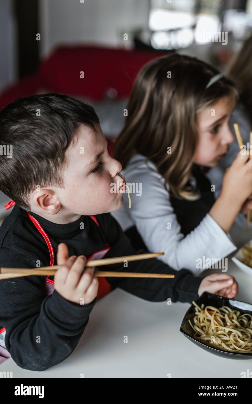 boy and girl eating tasty noodles with vegetarian cutlets and ...