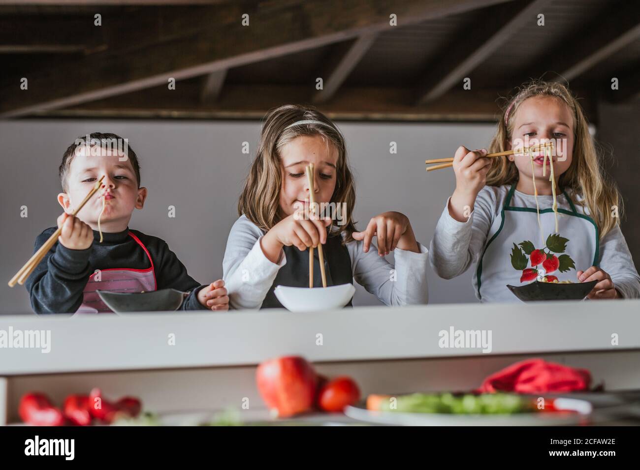 boy and two girls eating tasty noodles with vegetarian cutlets and ...