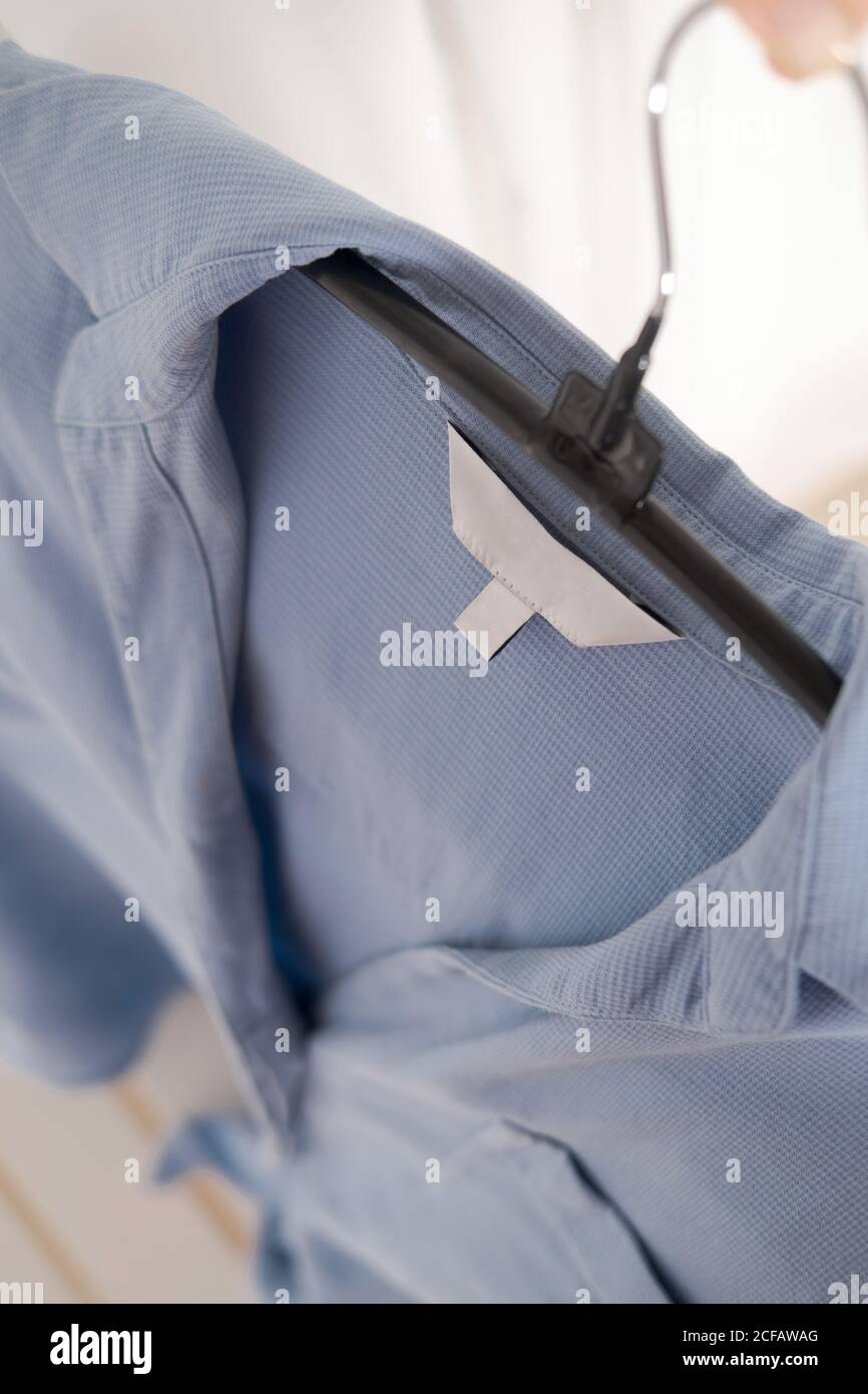 Clothing label on ligh blue fabric. Fashion brand name mock up, closeup ...