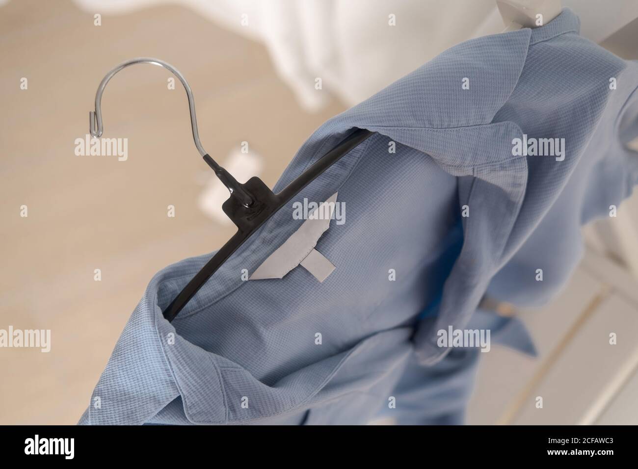 Clothing label on ligh blue fabric. Fashion brand name mock up, closeup ...