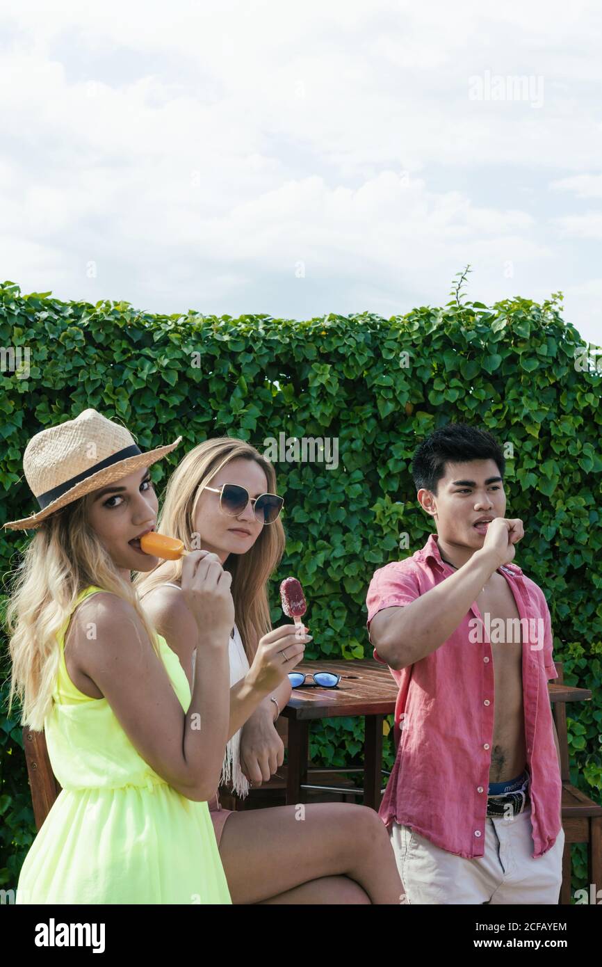 Friends eating ice cream while talking on the terrace of a bar Stock ...