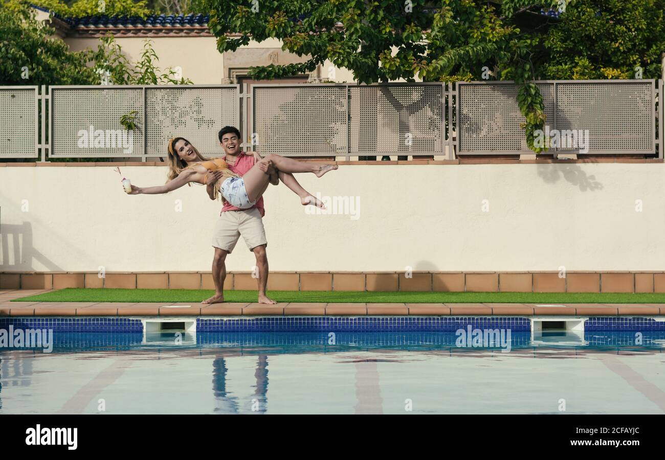 Group of friends having a pool party while they dance, laugh and drink ...