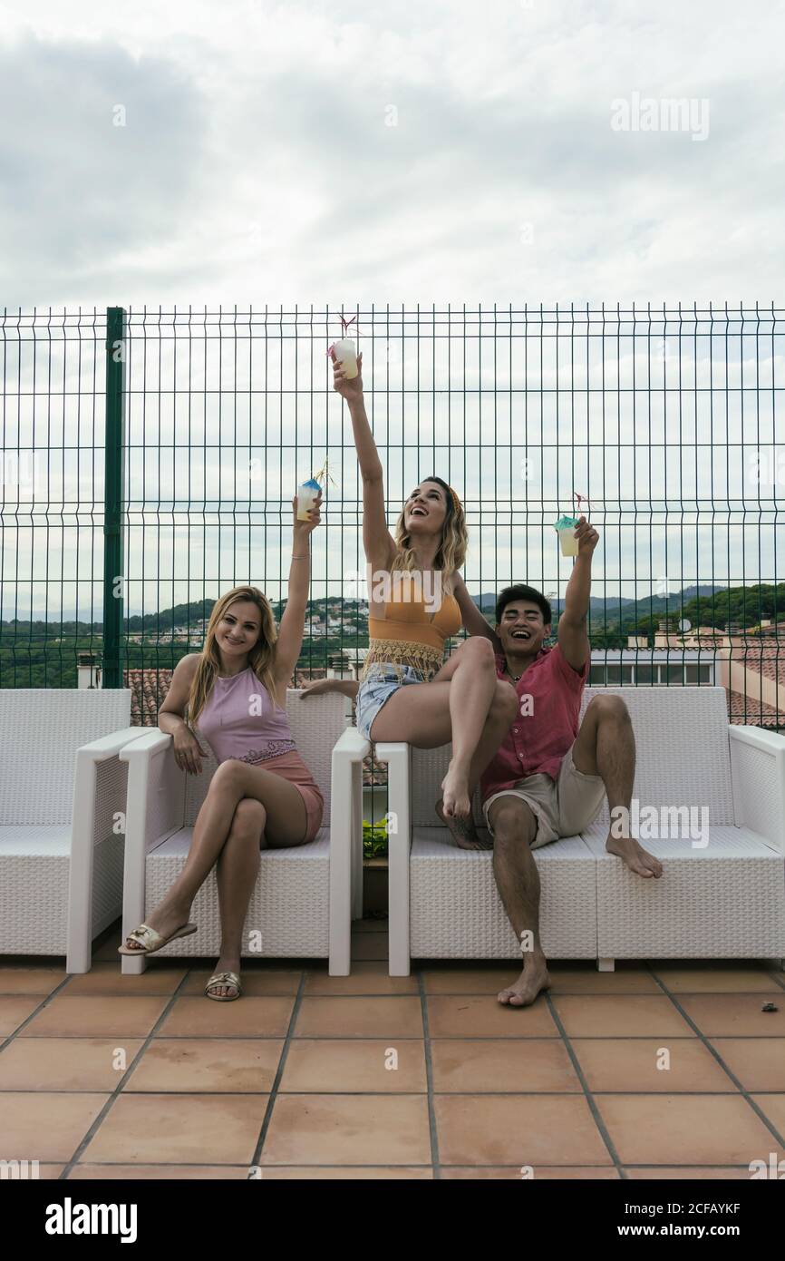 Group of friends having a pool party while they dance, laugh and drink ...